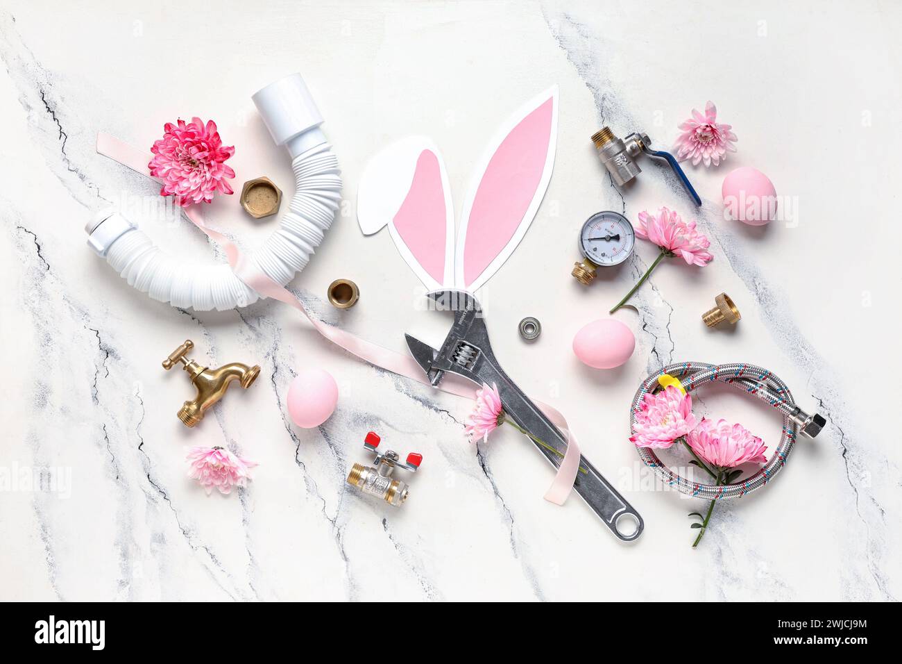 Composition with plumber's items, Easter eggs and flowers on light ...