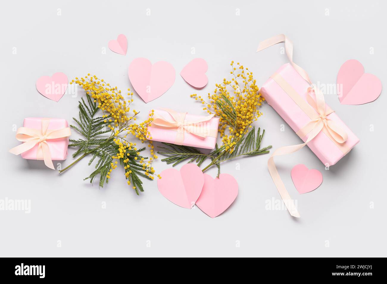 Mimosa and gift boxes on white background Stock Photo - Alamy