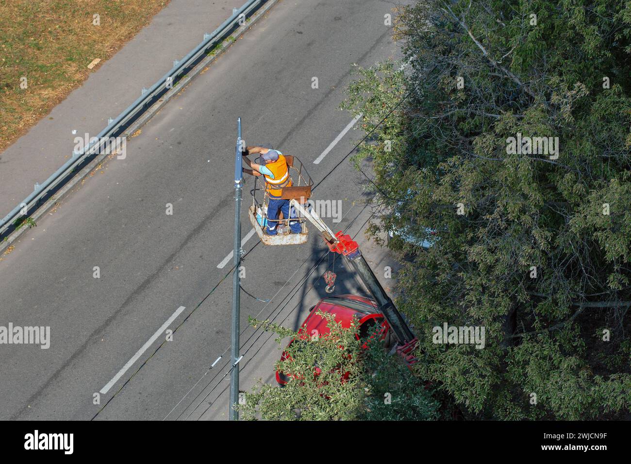 Workers installers on a pneumatic car lift are installing a new street ...