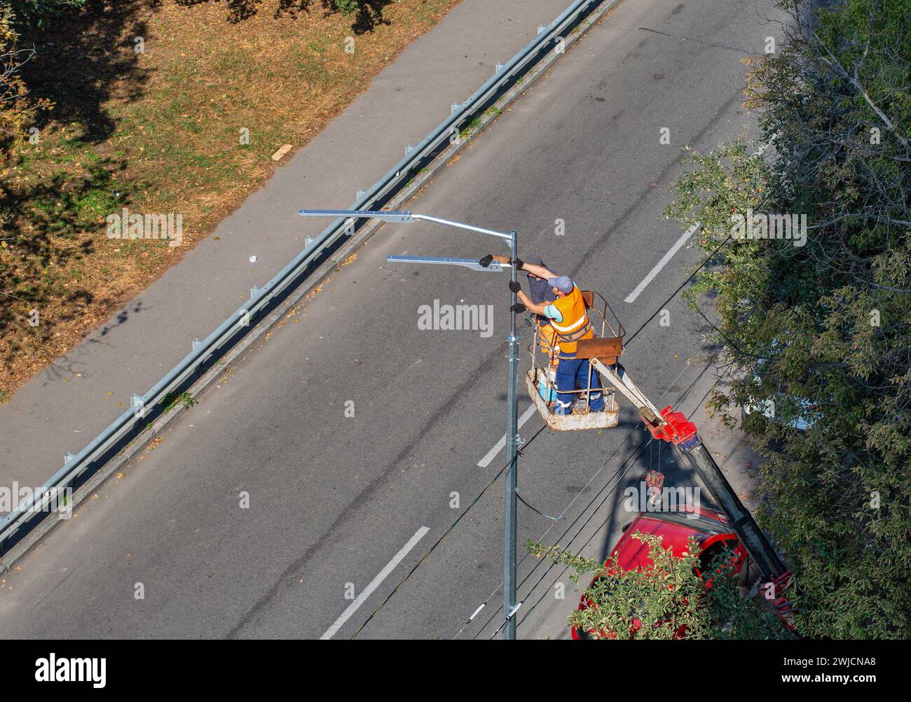 Workers installers on a pneumatic car lift are installing a new street ...