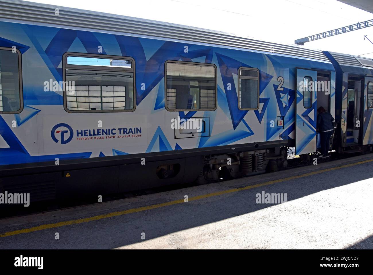 Passenger getting on a Hellenic Railways train at Thessaloniki Railways ...