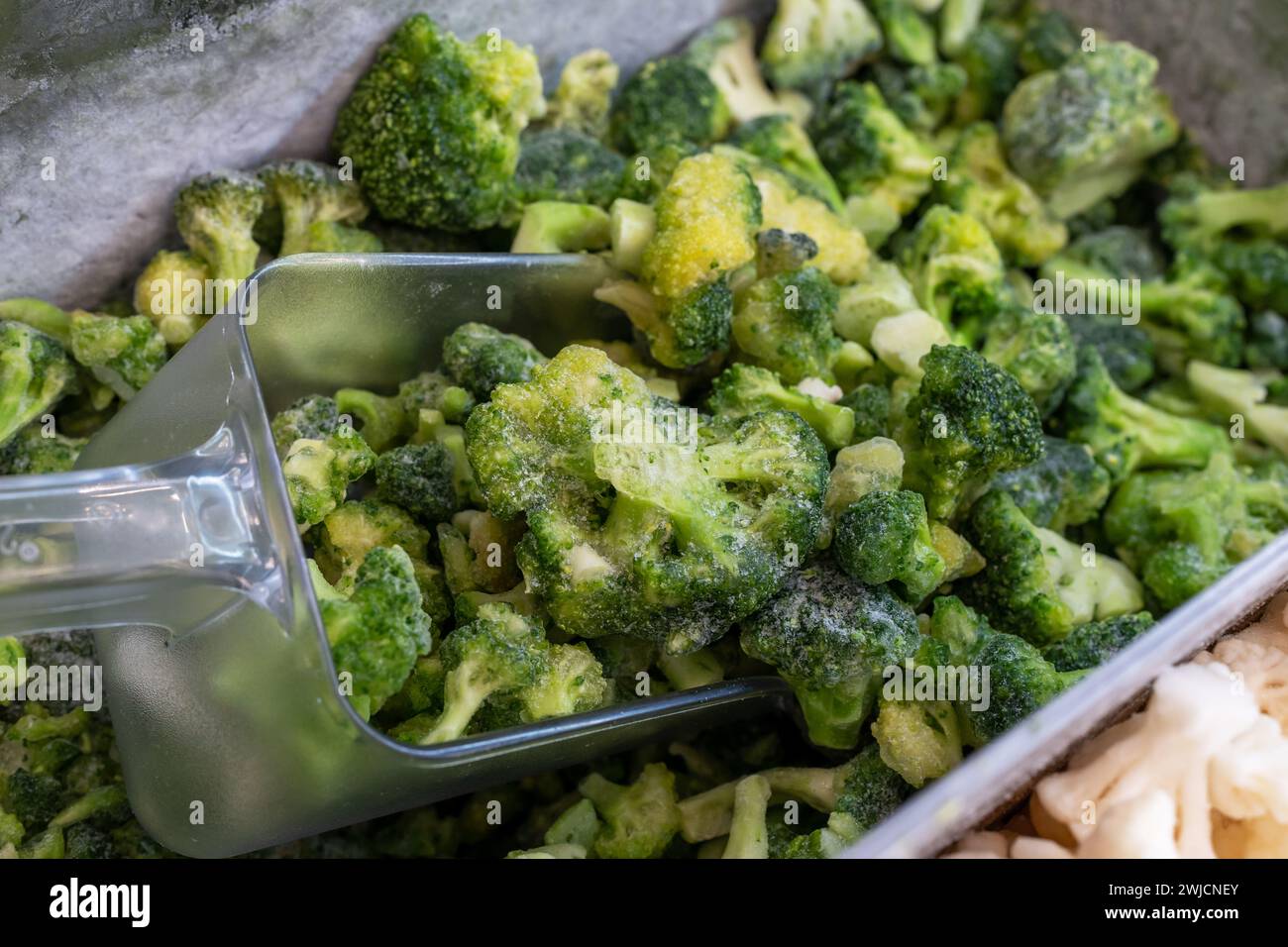 Frozen vegetables. Selling frozen broccoli in the fridge of a grocery ...