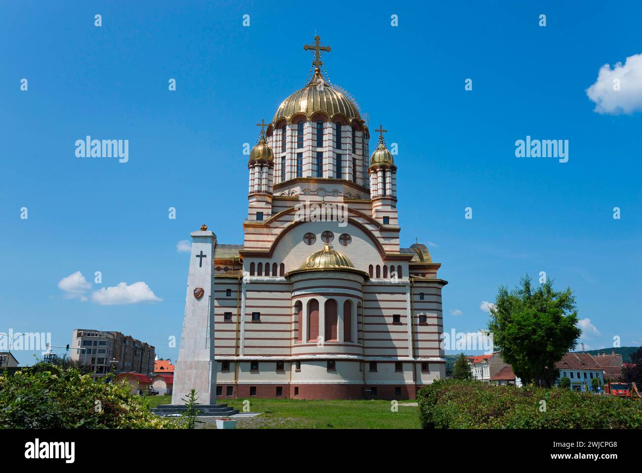 Church with golden domes against a clear sky, embedded in urban ...