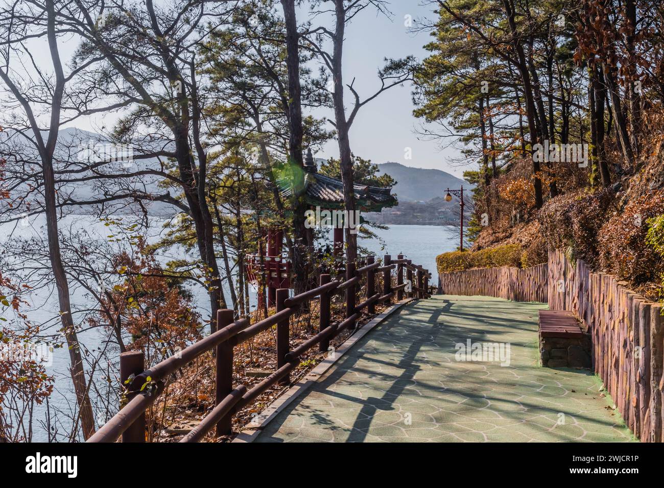 Concrete walkway with wooden railing at next to oriental gazebo at ...