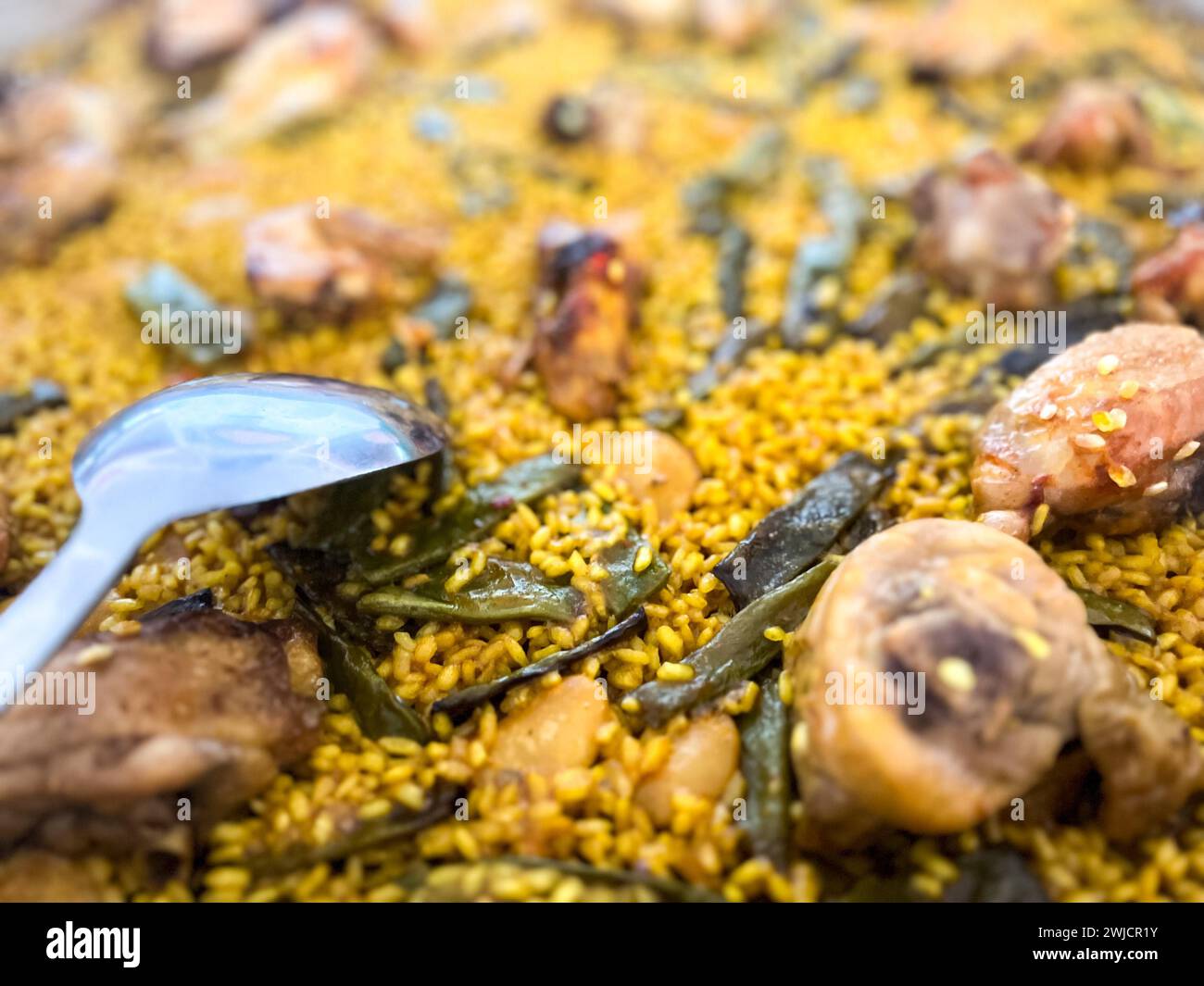 Chicken paella.Close up of a paella pan with yellow rice, chicken and ...