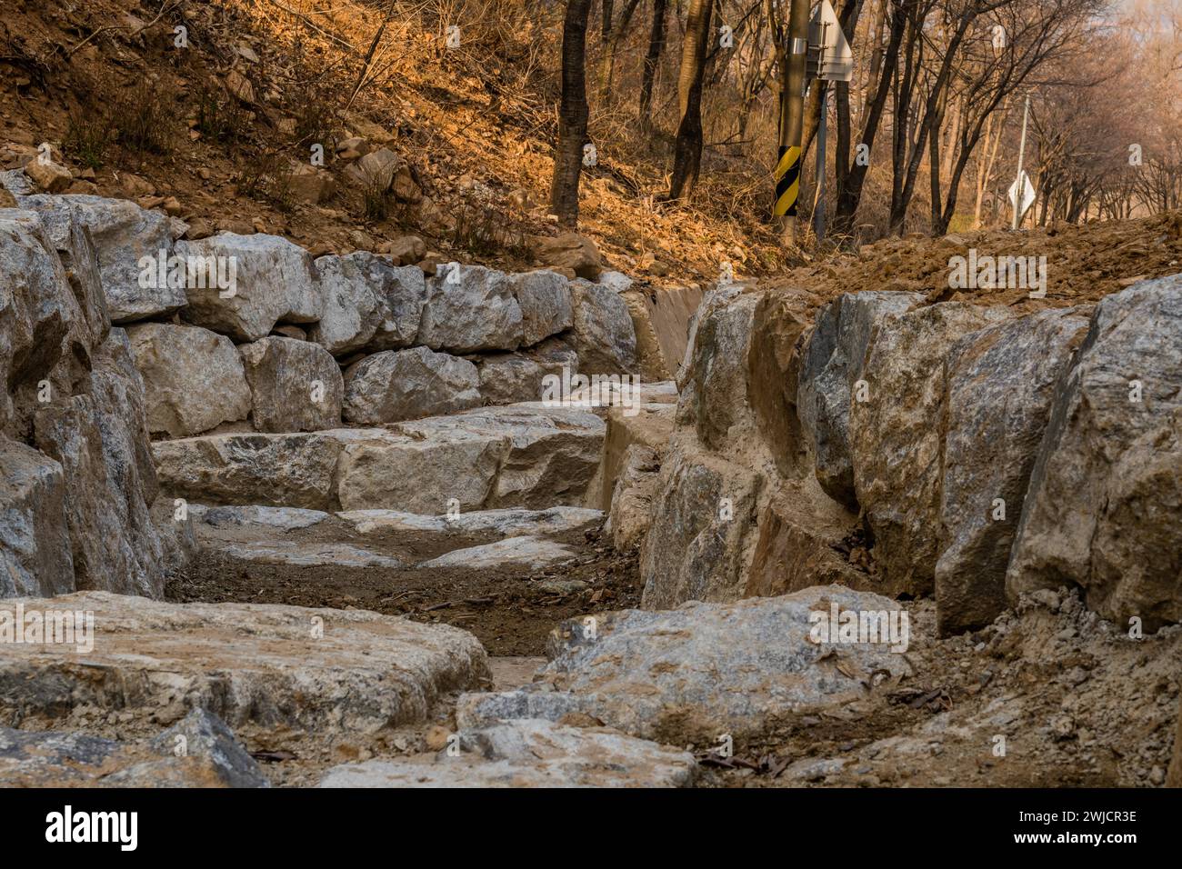 Drainage ditch constructed of large boulders on side of mountain on ...