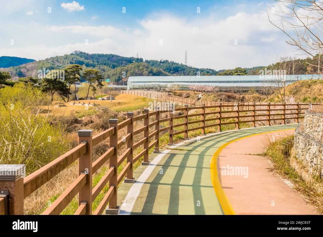 Pedestrian walkway and bike path in rural farming area. Graveyard in ...