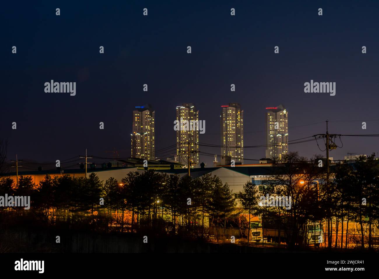 Night view of tall apartment buildings behind buildings in industrial ...