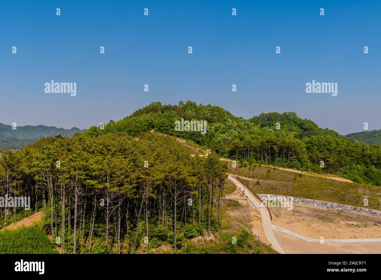 Vacant field and walking trails at bottom of hill viewed from top of ...