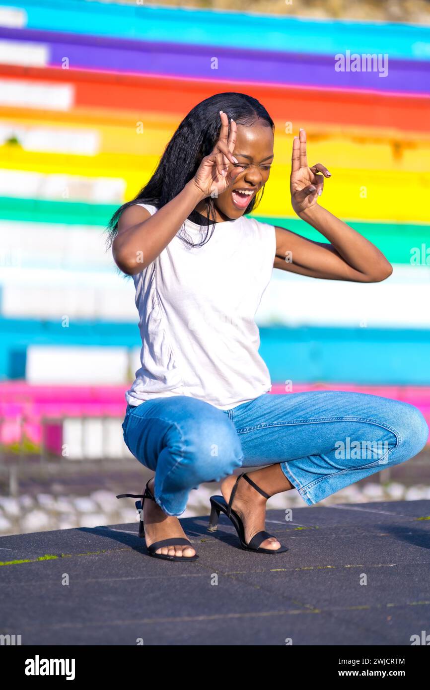 Vertical side view of a cool african woman gesturing victory with hands ...