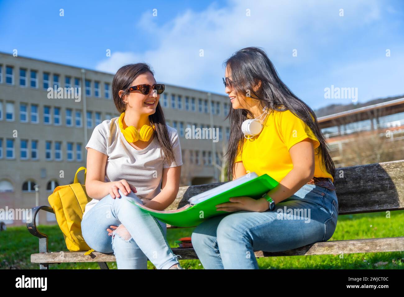 Low angle view photo of two cool friends studying together outside the ...