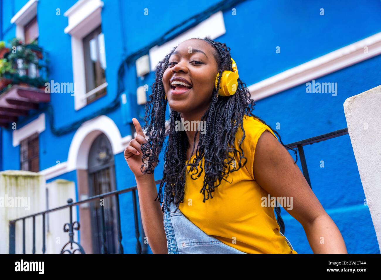 African woman singing to the camera and dancing in the street next to a ...