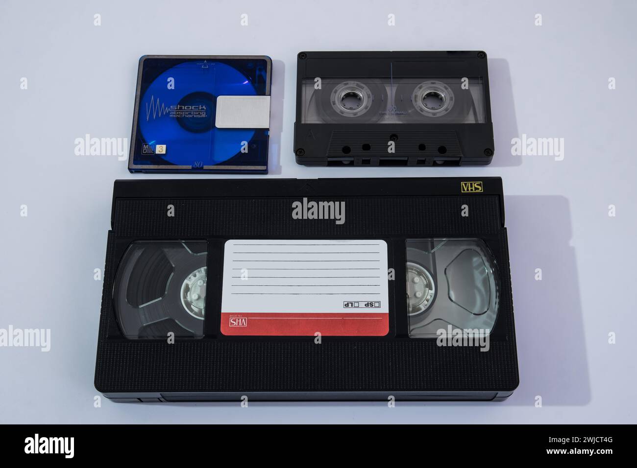 A collection of old storage media including a VHS tape, a cassette tape ...