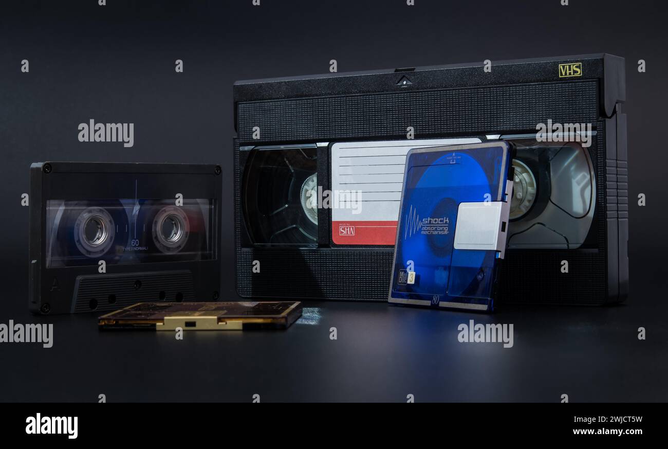 An array of outdated storage media including VHS, cassette, floppy disk ...