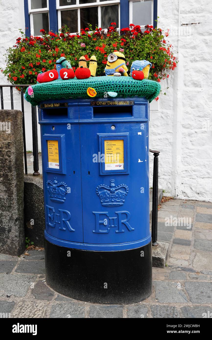 Blue Guernsey Post letterbox with emblem of Queen Elizabeth II in the ...