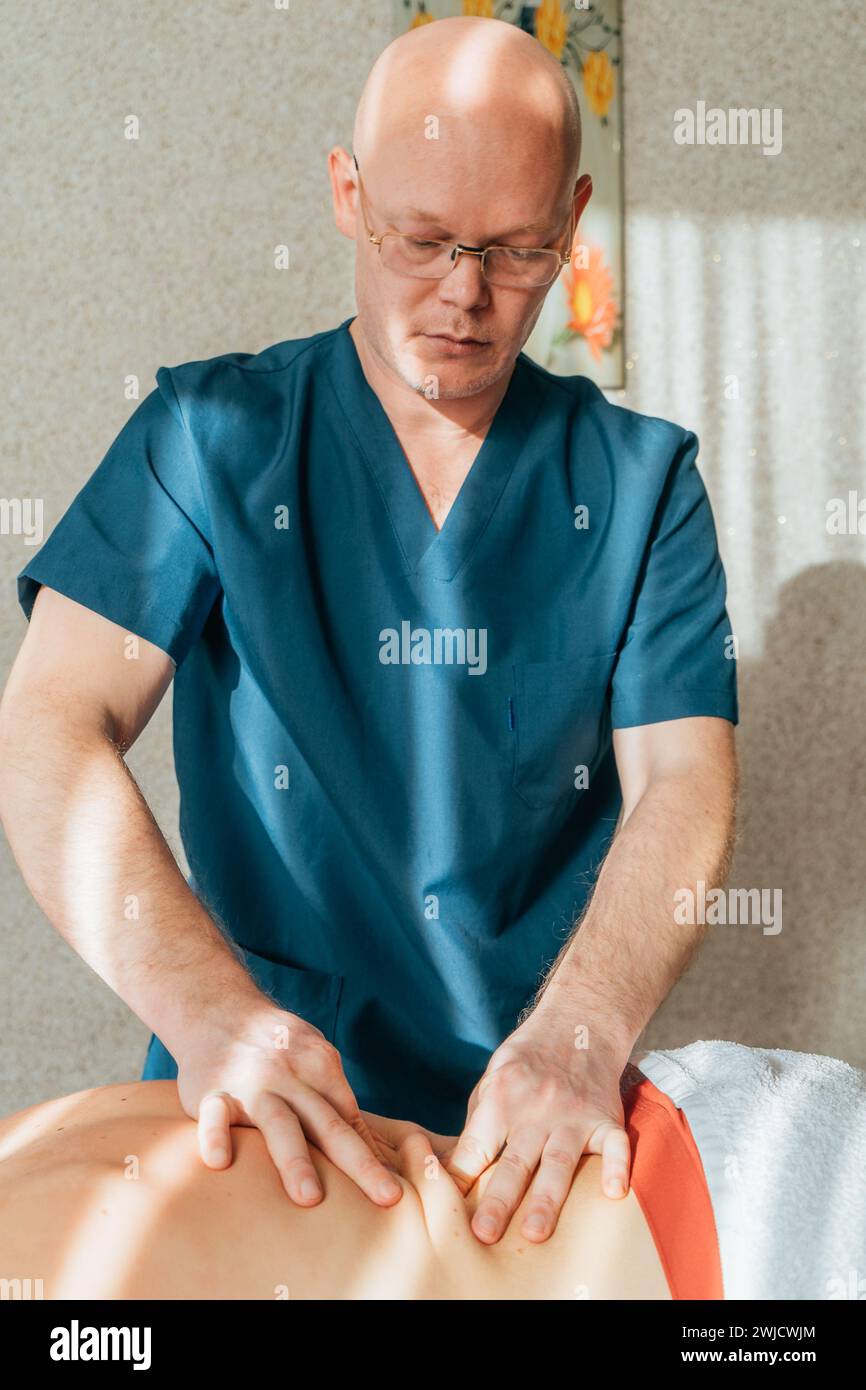 Professional male masseur kneads hi-res stock photography and images ...