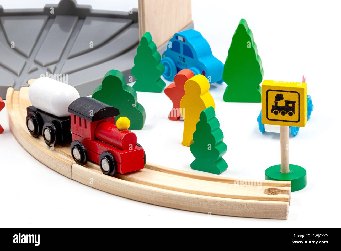 Children's toy train with two cars on a wooden railroad. Trees and ...