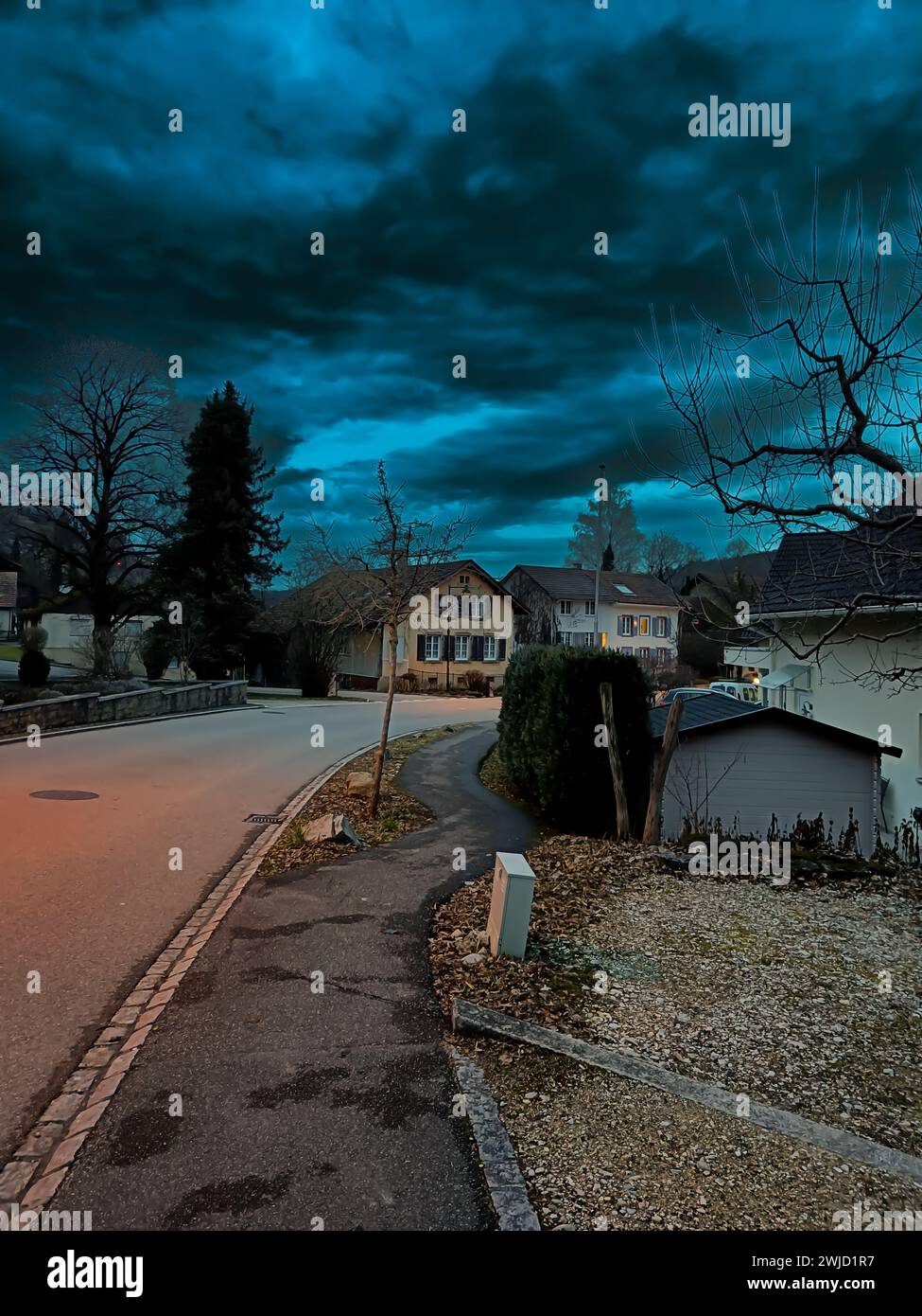 A scenic perspective of a residential street lined with houses under a ...