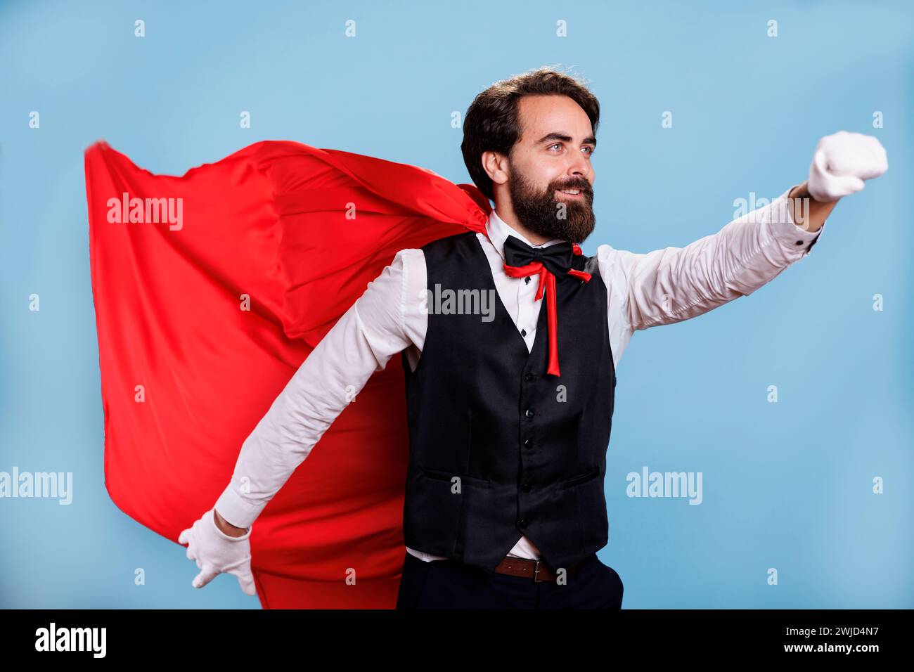 Strong superhero character with red cape posing against blue background ...