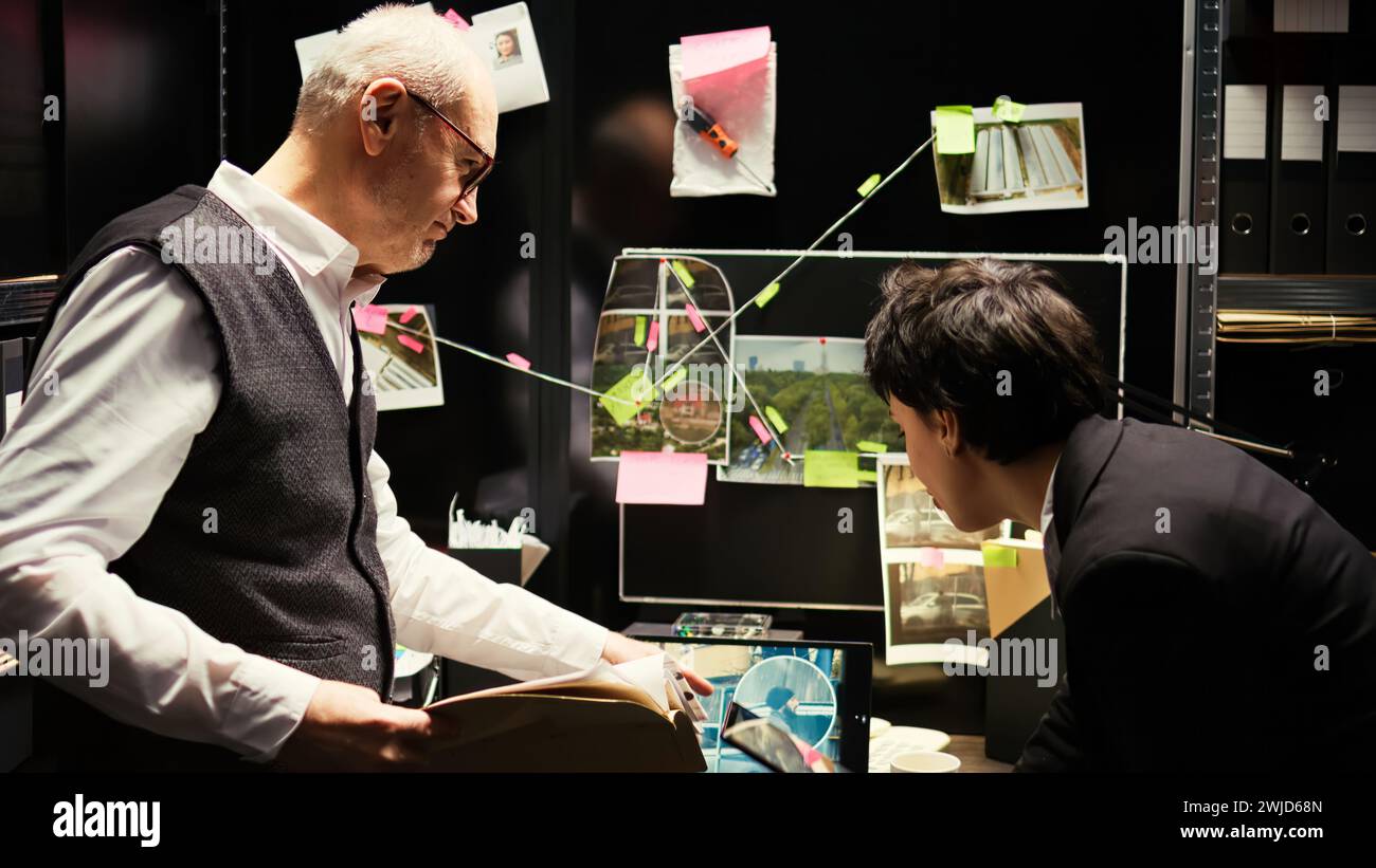 Police officers on duty at agency, reviewing surveillance footage for ...