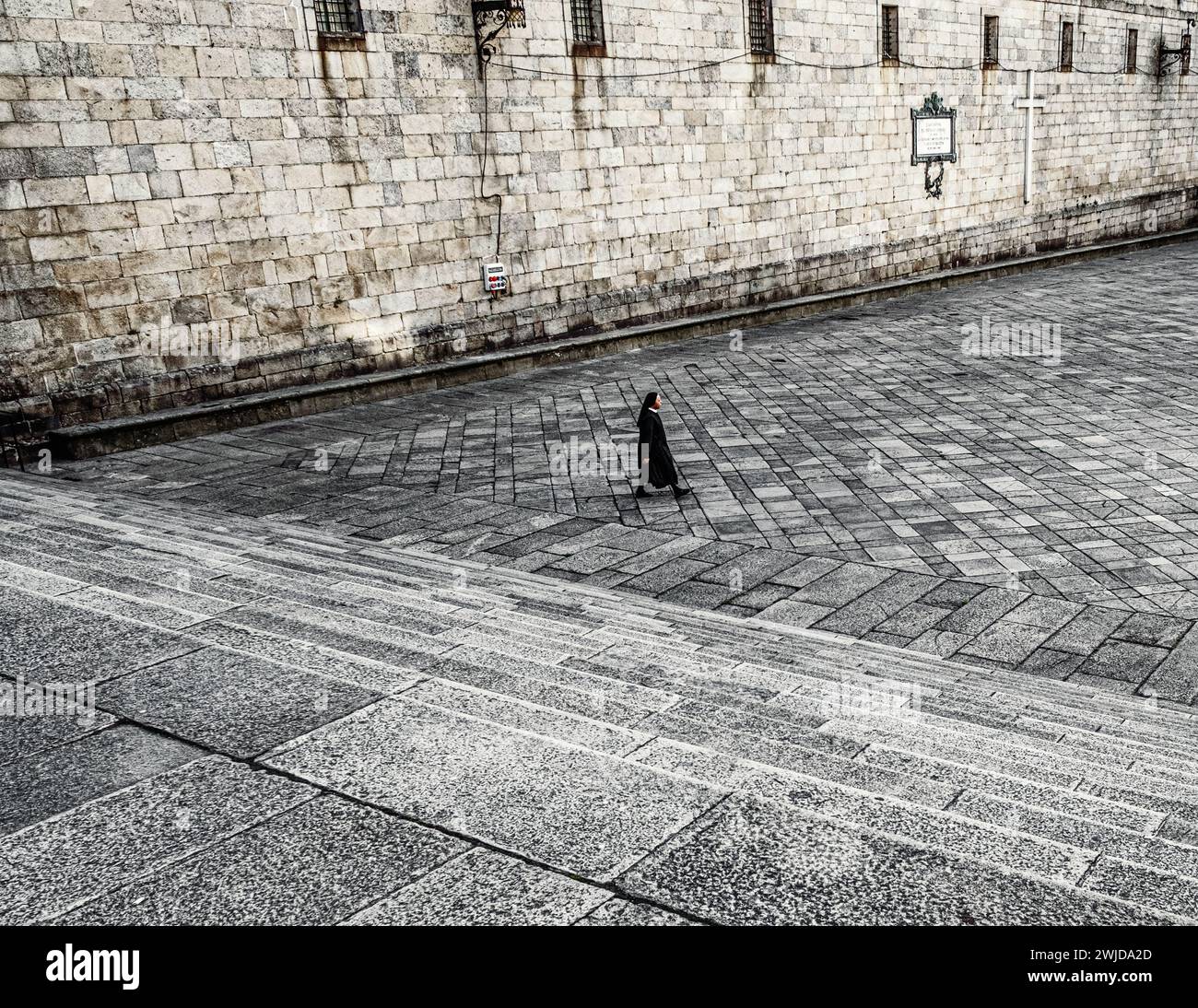 Christian nun walking through Praza da Quintana in the old town of ...