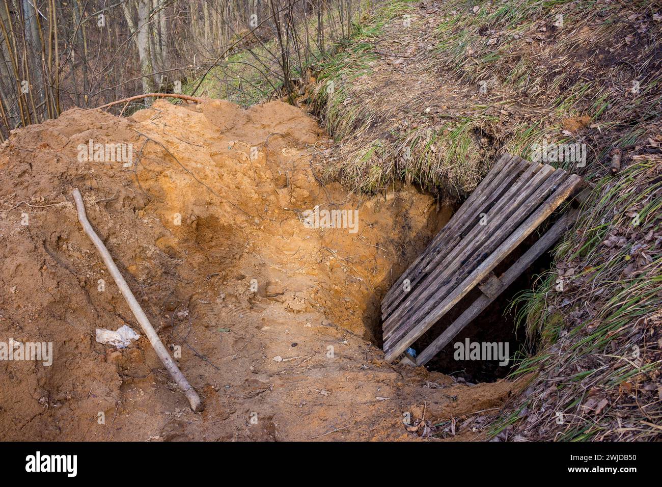 A dugout dug in the sand covered with a wooden pallet, digging tunnels ...