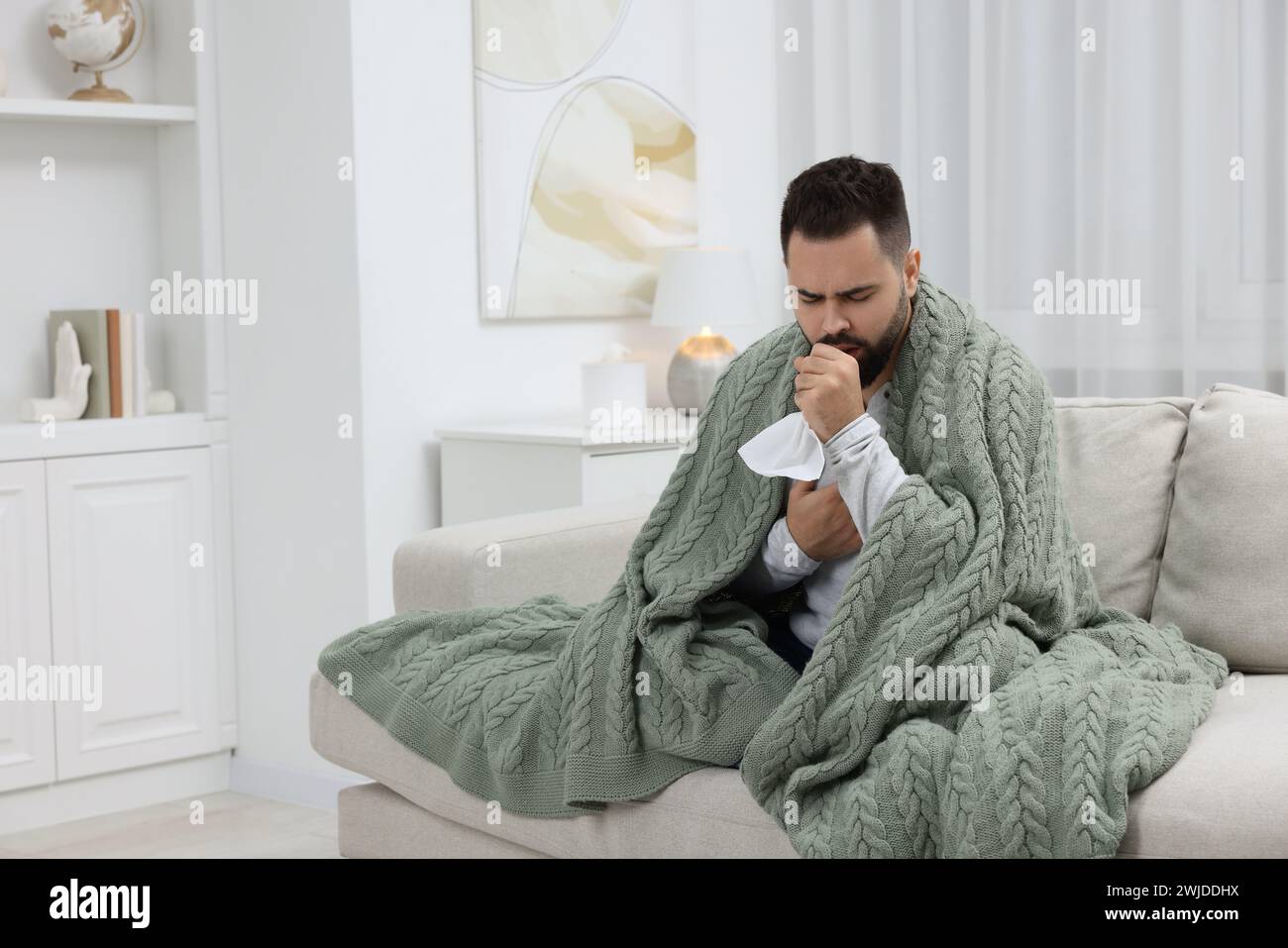 Sick man with tissue coughing at home Stock Photo - Alamy