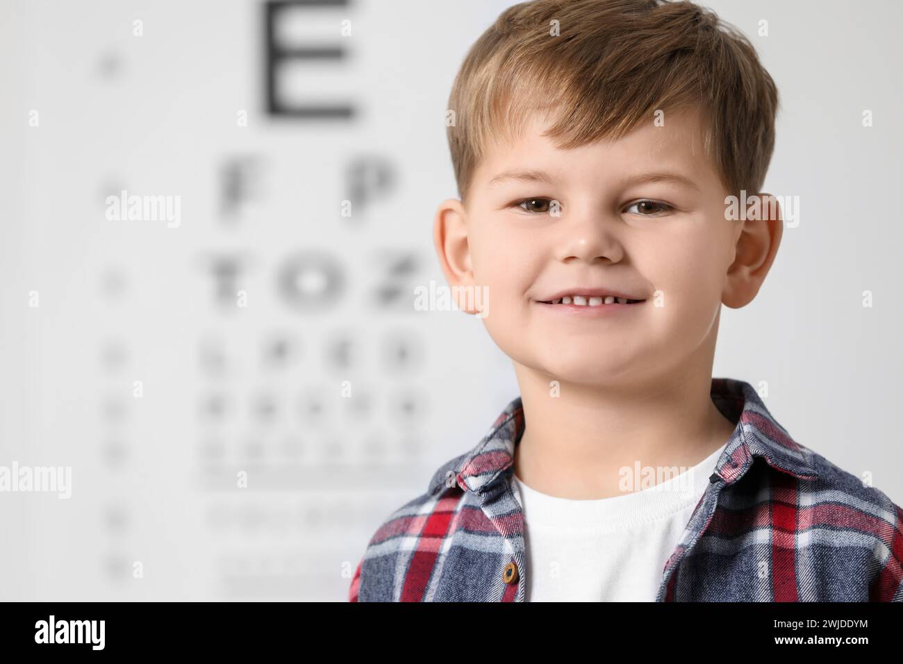 Cute little boy against vision test chart Stock Photo - Alamy