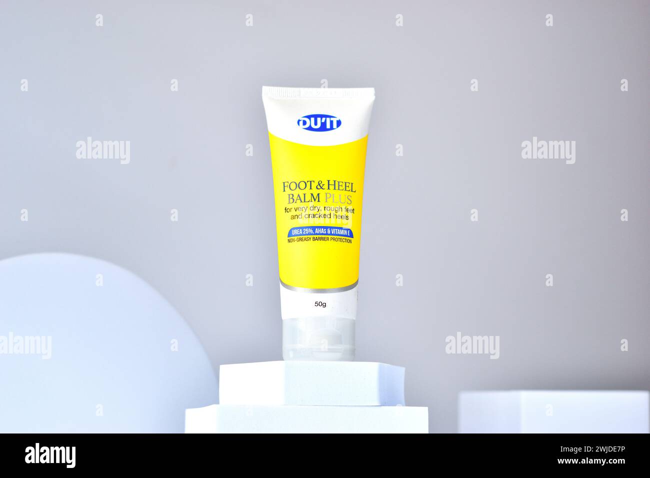 image of a heel cream in a yellow tube with a white bokeh background ...