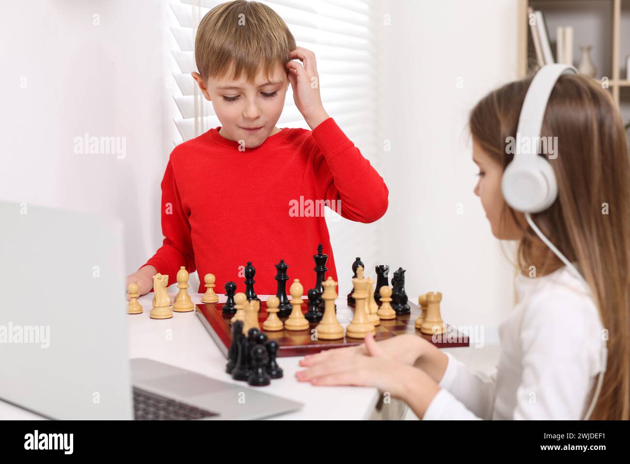 Children playing chess following online lesson indoors Stock Photo - Alamy