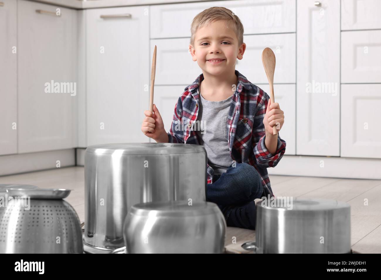 Little boy pretending to play drums on pots in kitchen Stock Photo - Alamy
