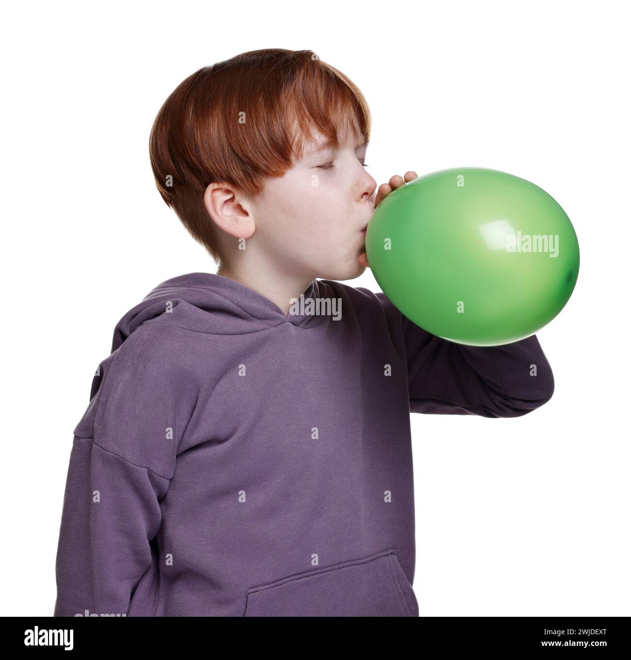 Boy inflating green balloon on white background Stock Photo - Alamy