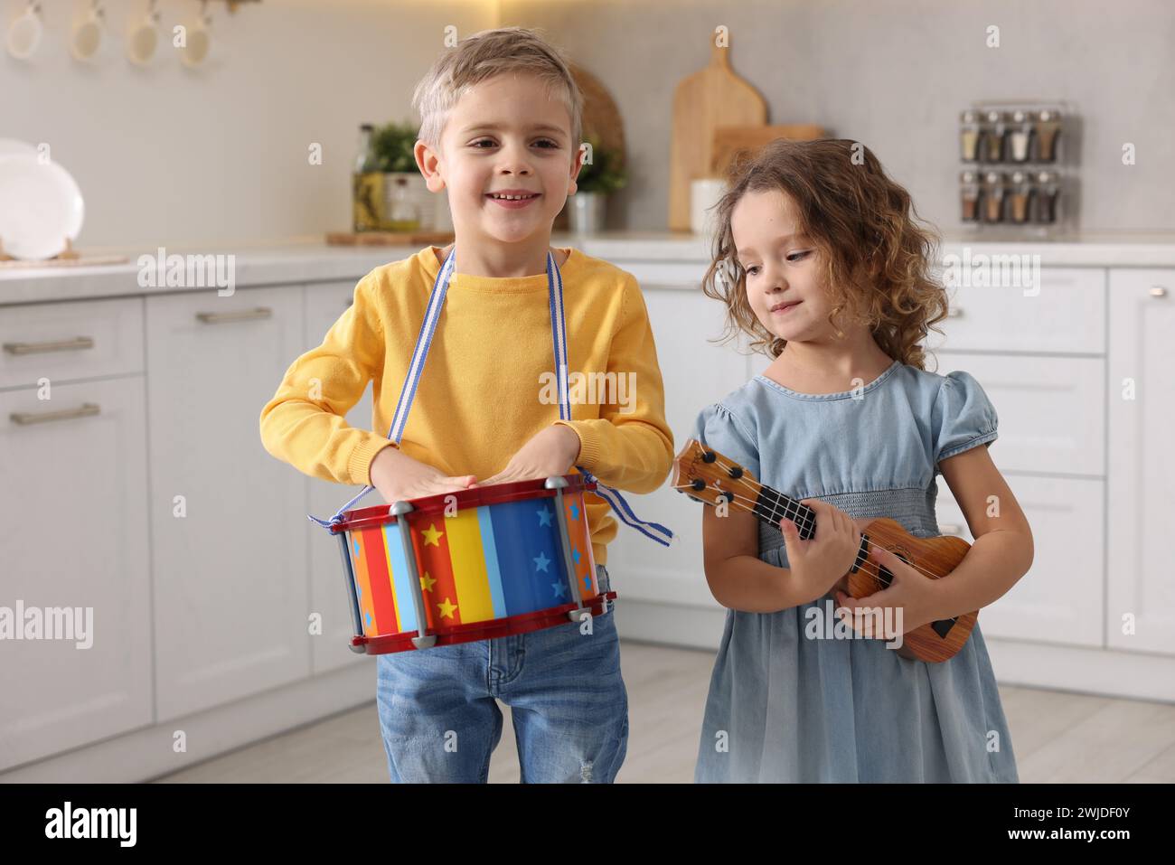 Little children playing toy musical instruments in kitchen Stock Photo ...