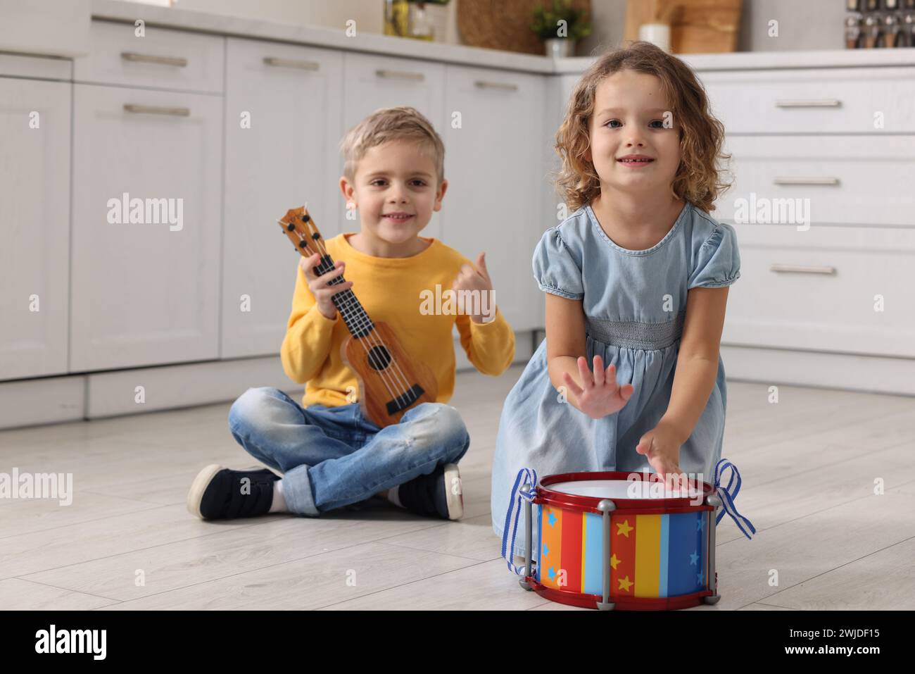 Little children playing toy musical instruments in kitchen Stock Photo ...