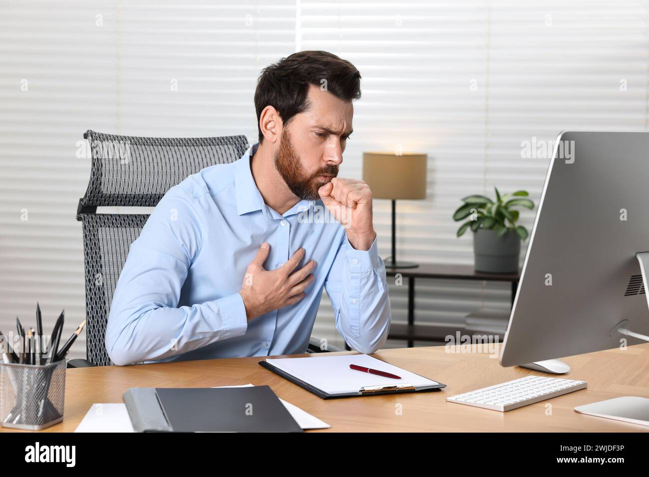 Sick man coughing at workplace in office. Cold symptoms Stock Photo - Alamy