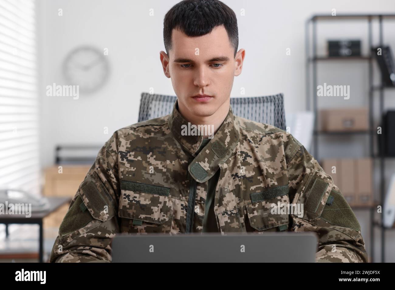 Military service. Young soldier working in office Stock Photo - Alamy