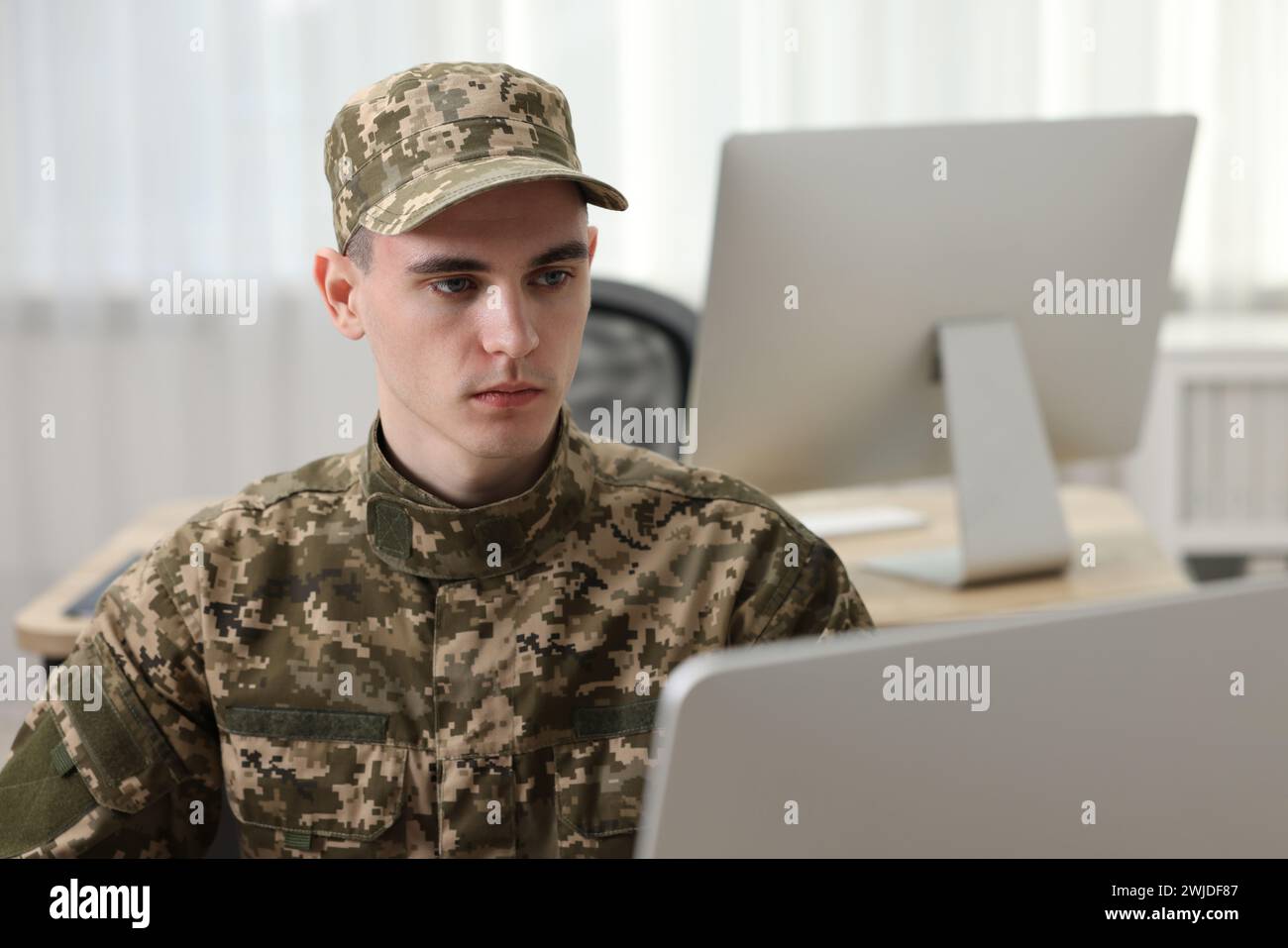 Military service. Young soldier working in office Stock Photo - Alamy