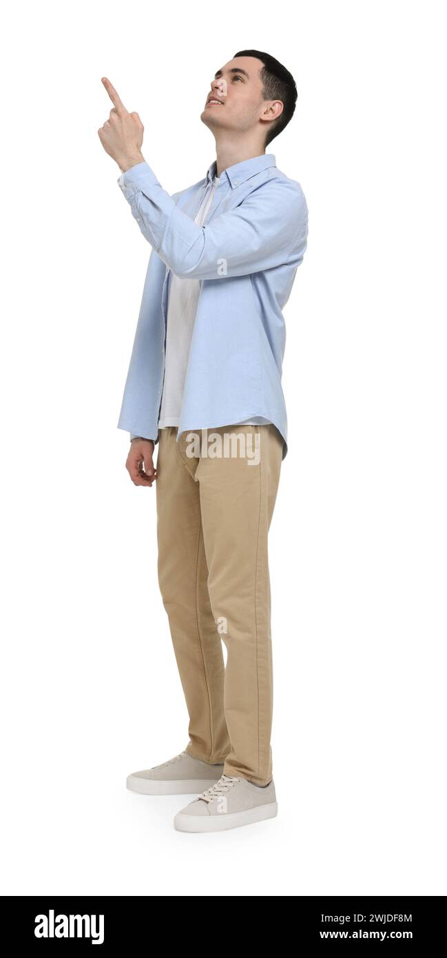 Young man pointing at something on white background Stock Photo - Alamy