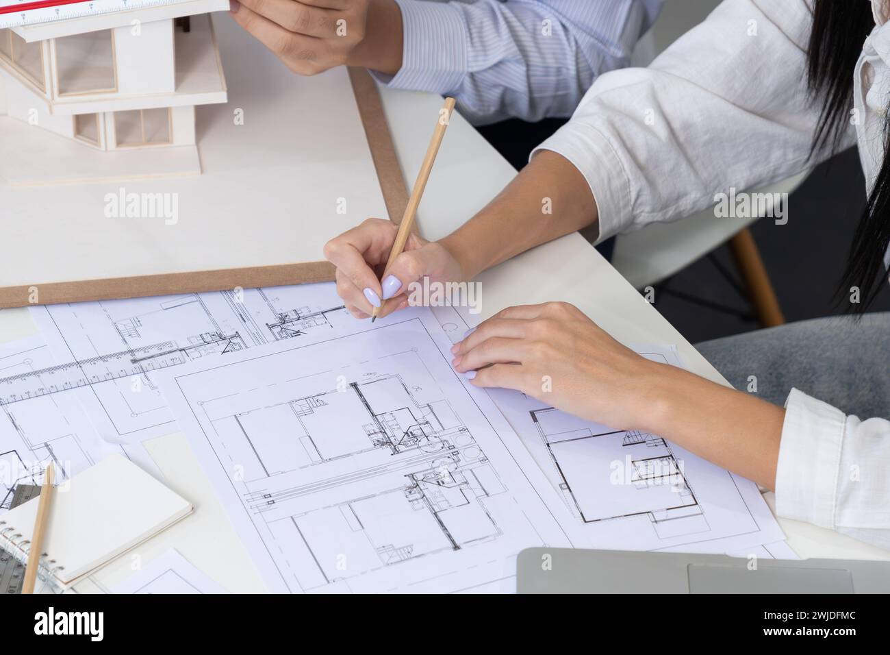 Professional male engineer hand measure house model by using ruler ...