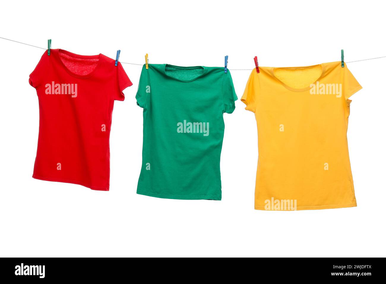 Different bright t-shirts drying on washing line against white ...