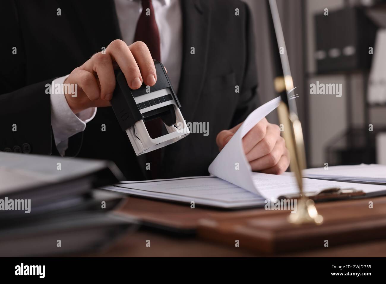 Notary stamping document at table in office, closeup Stock Photo - Alamy