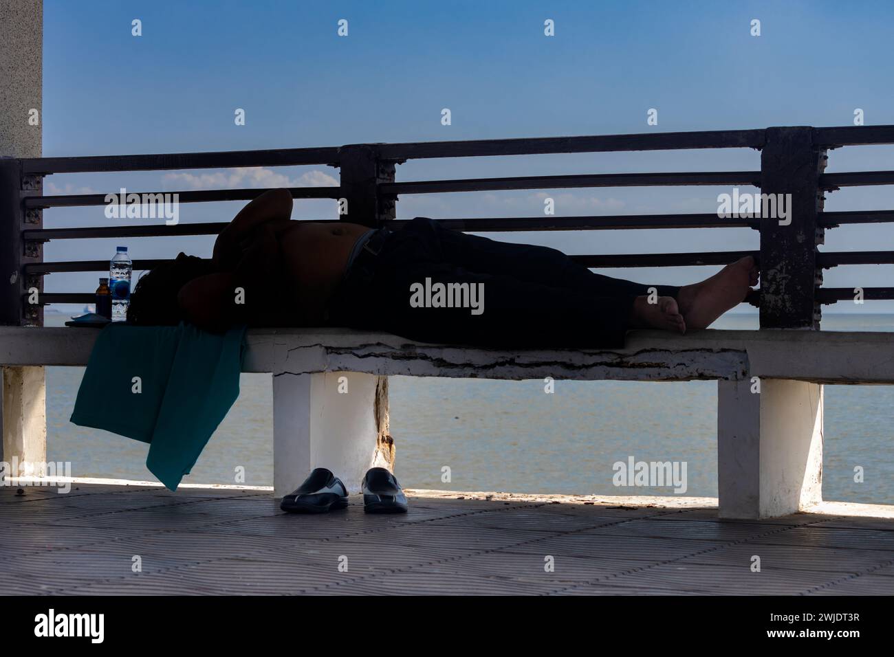 Tired man sleeping on a bench on the seashore Stock Photo - Alamy