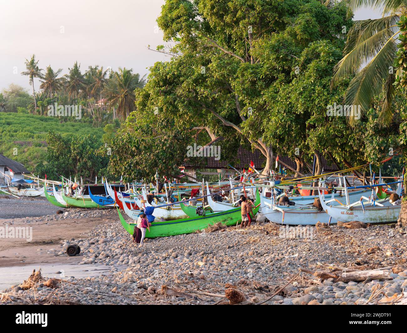 Traditional Indonesian fishing boat with outriggers at sunset on a ...
