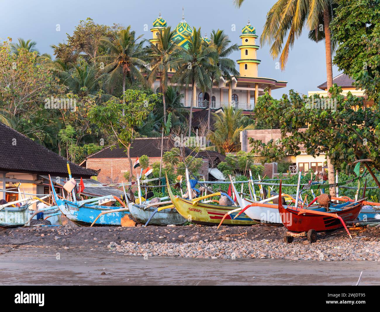 Traditional Indonesian fishing boat with outriggers at sunset on a ...