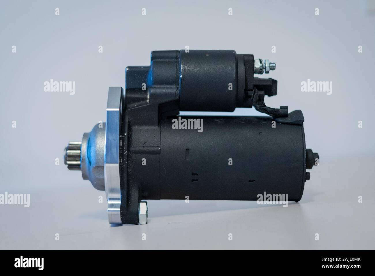 Side view of automotive engine starter. Visible black refurbished and ...
