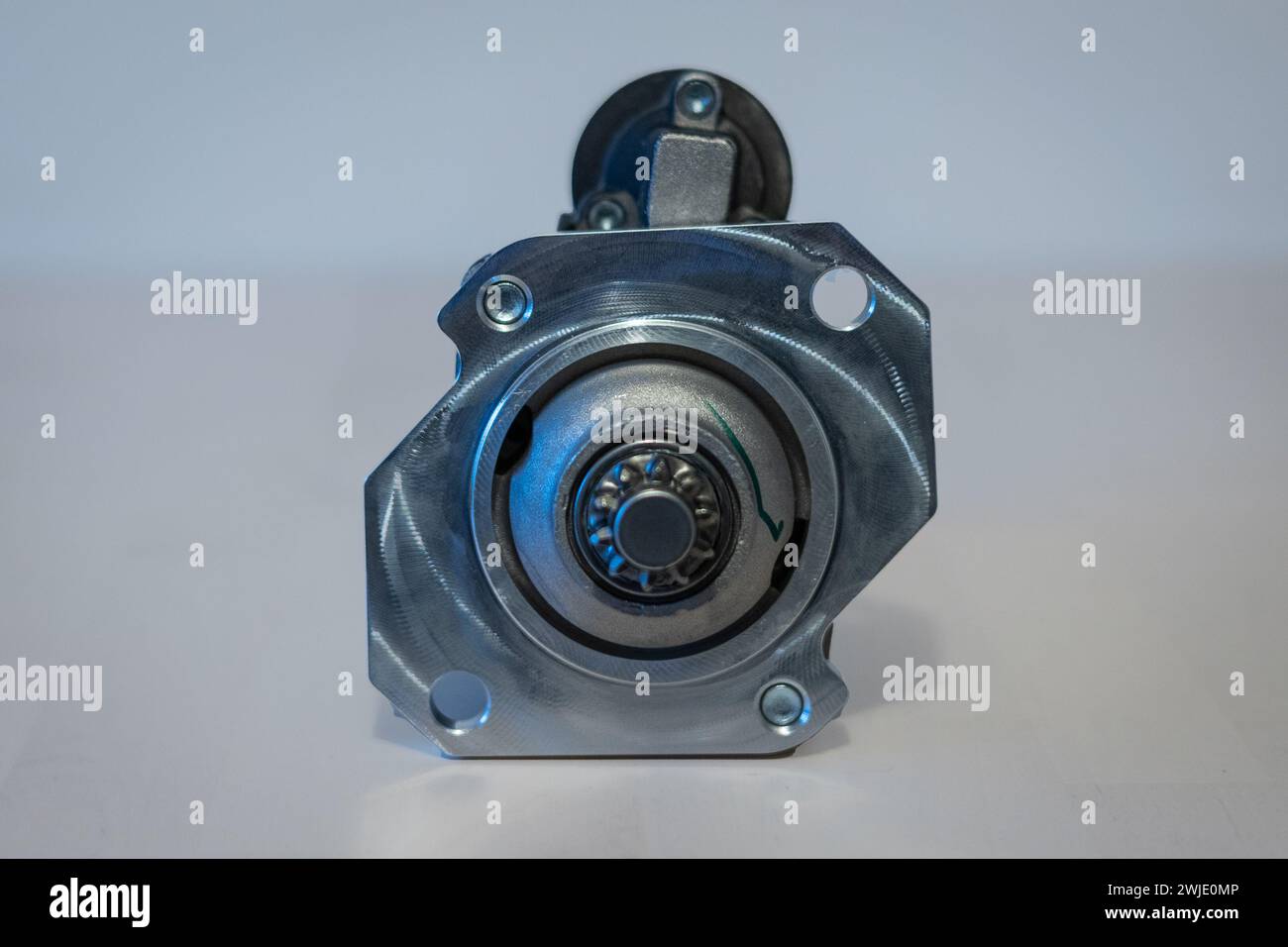 Rear view of automotive engine starter. Visible black refurbished and ...