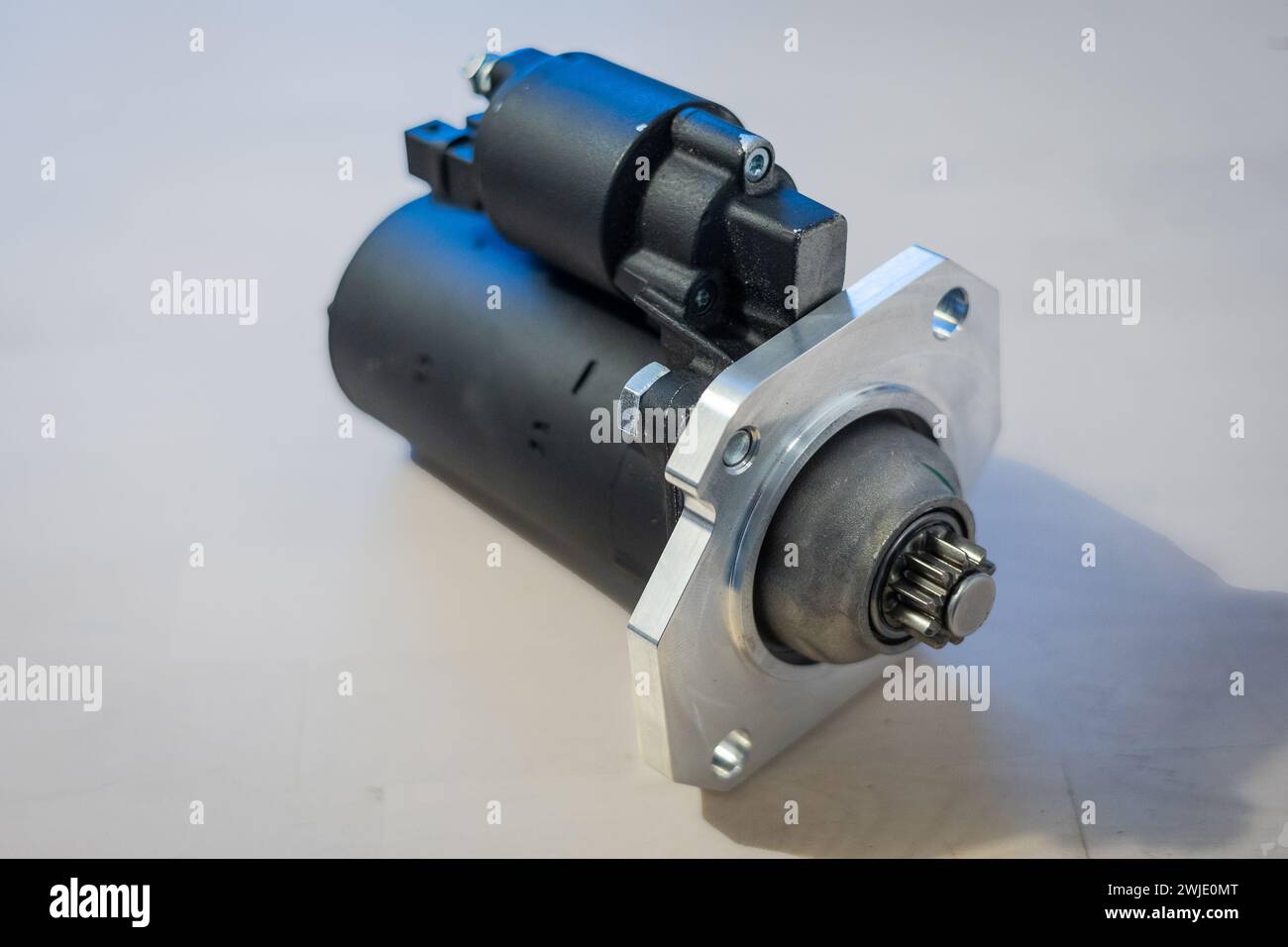 Side view of automotive engine starter. Visible black refurbished and ...
