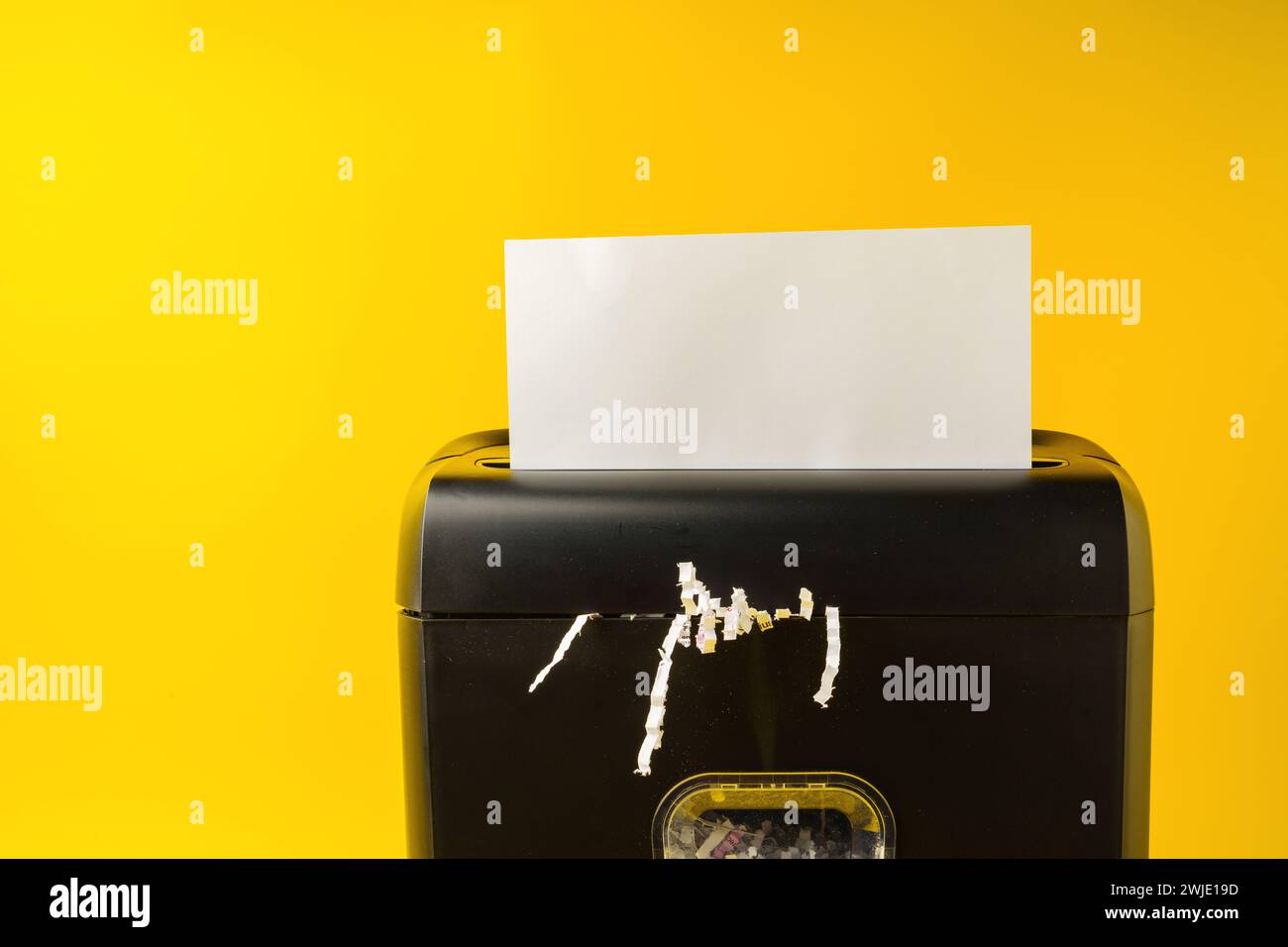 Office paper shredder on yellow studio background Stock Photo - Alamy
