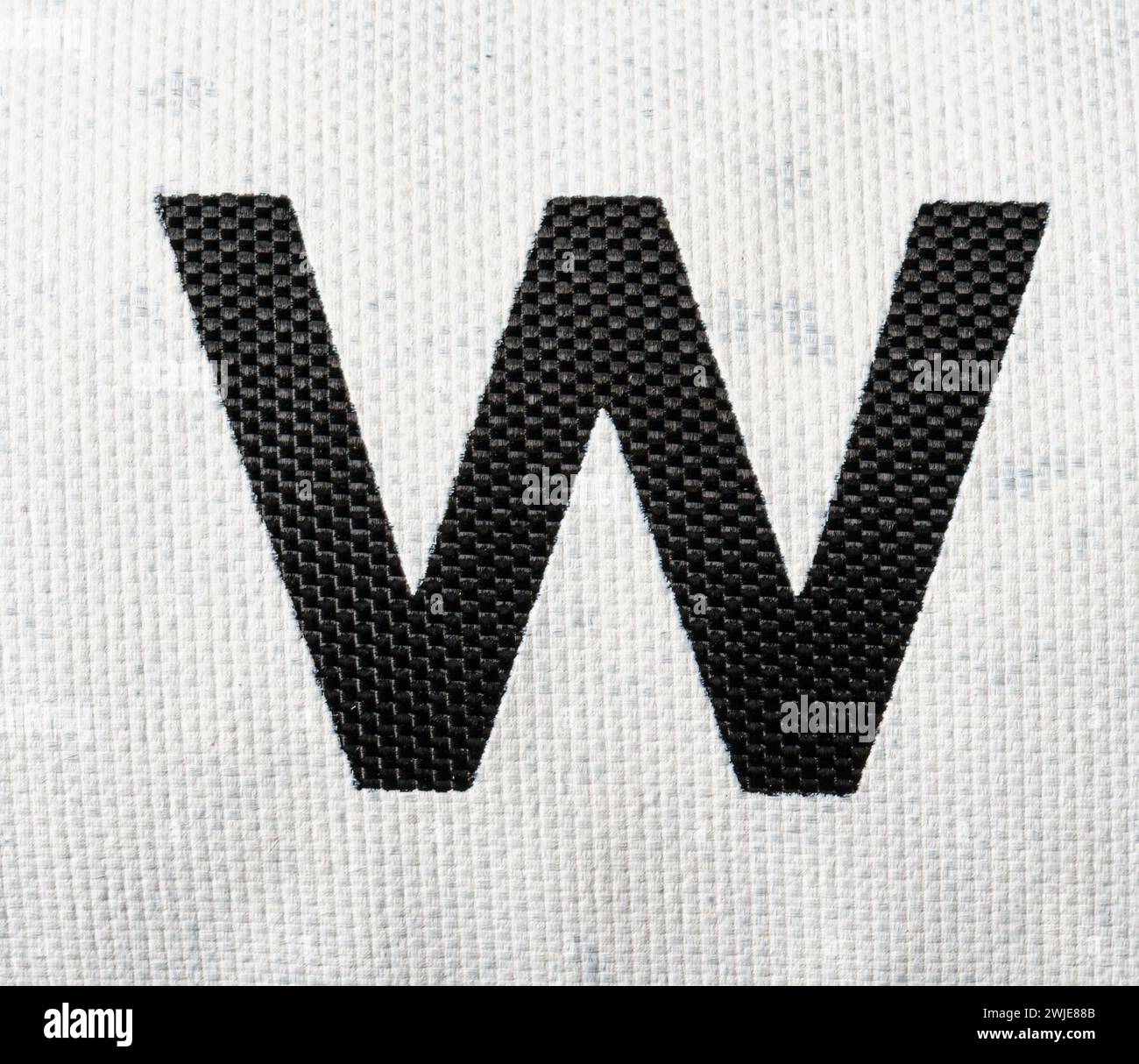 Black letter W on white painted fabric material. English alphabet ...