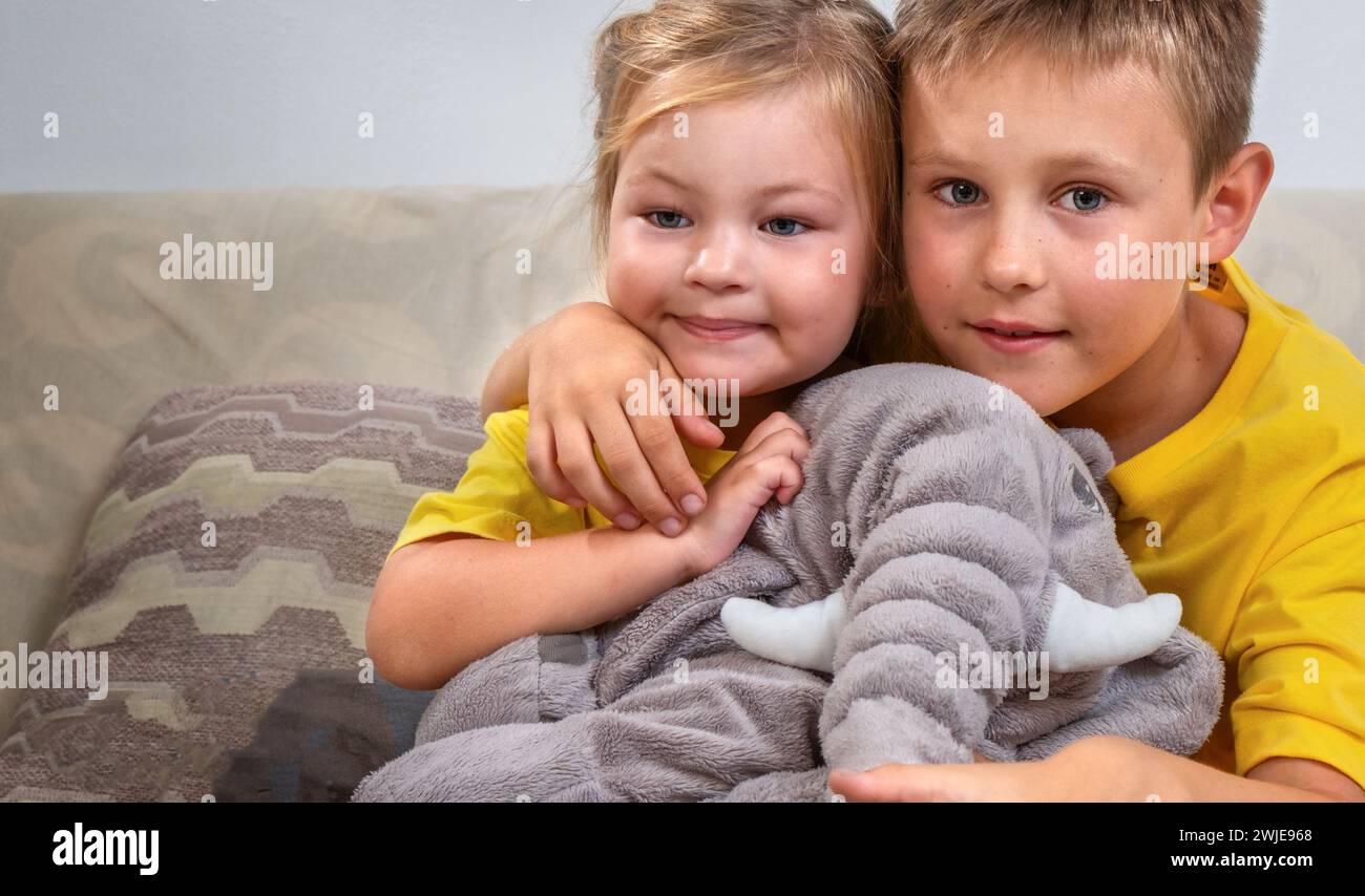 Portrait of children sibling on the sofa with a toy together Stock ...